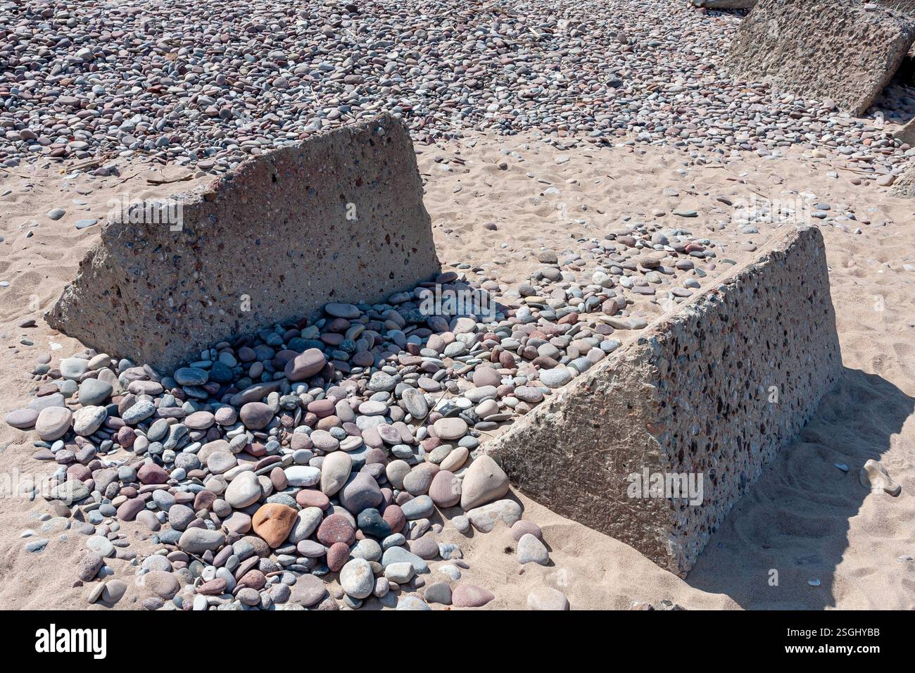 A view of large concrete blocks on a beach covered with various sized ...