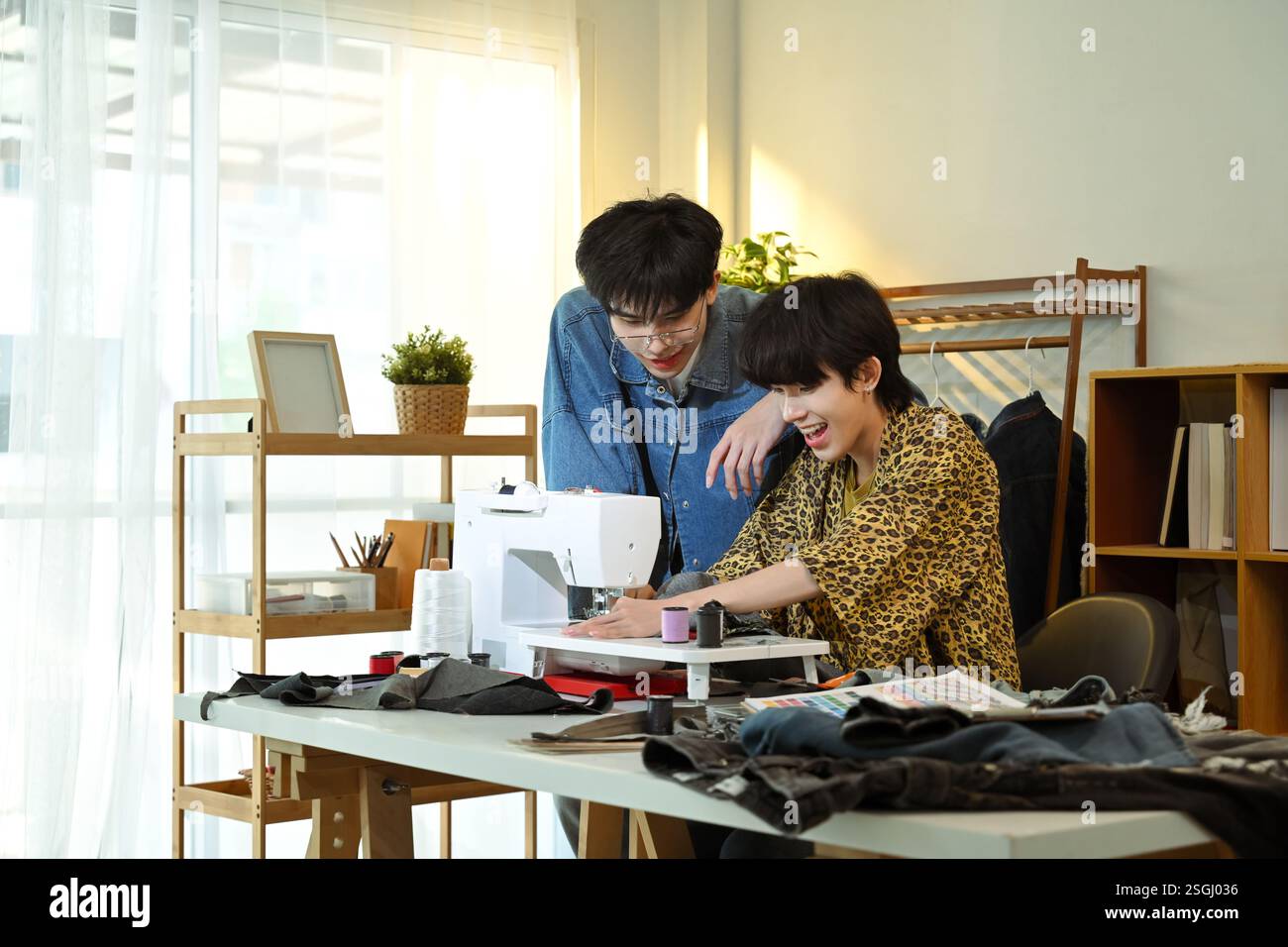Happy designers working on a new clothing project in a bright fashion ...