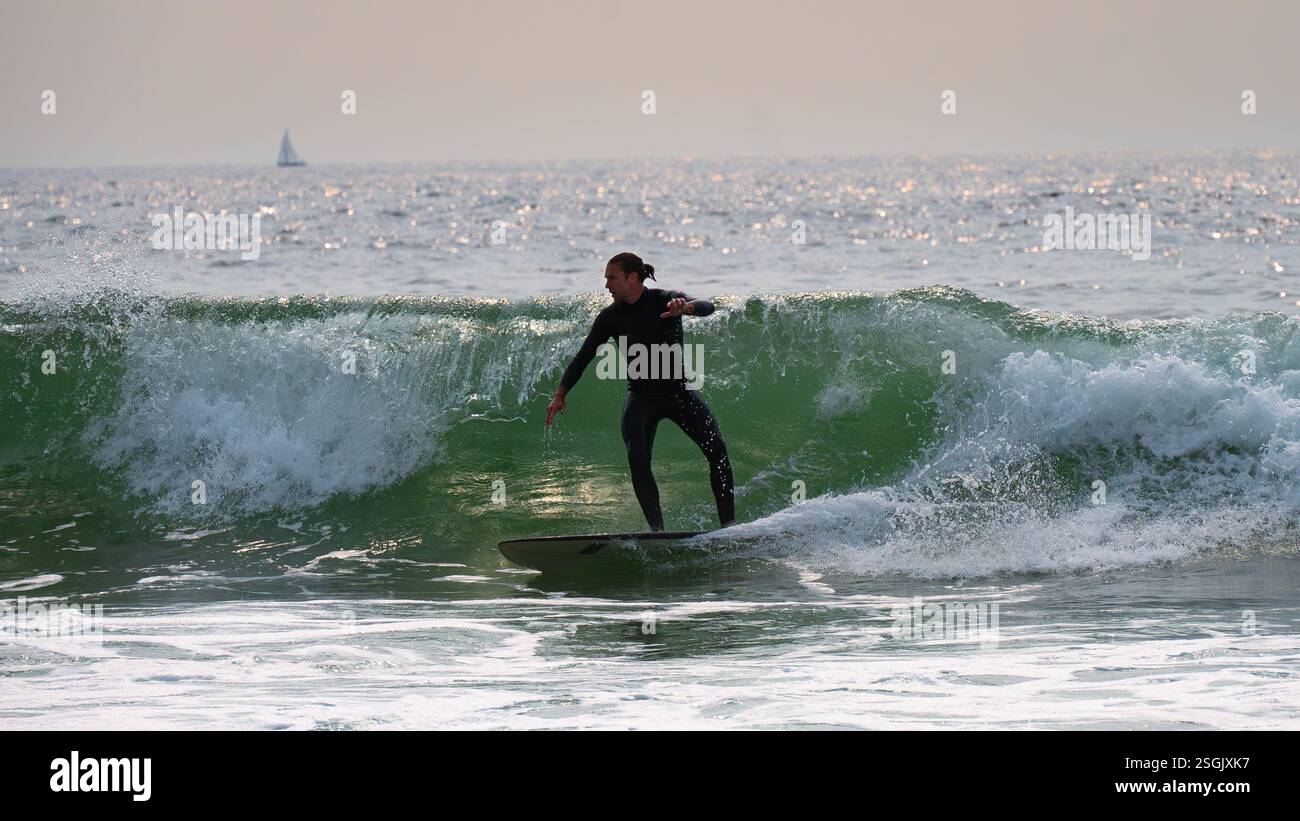 Surfer riding the waves on a beautiful sparkling sea on a summer day ...