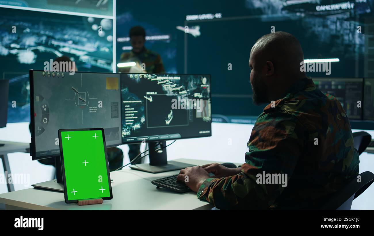Soldier gathering real time surveillance data next to mockup display in ...