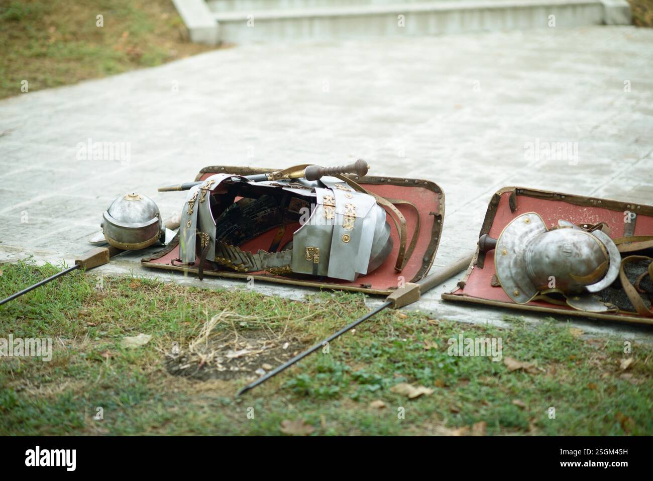 Metal armor pieces, including a chest plate and helmets, rest on the ...