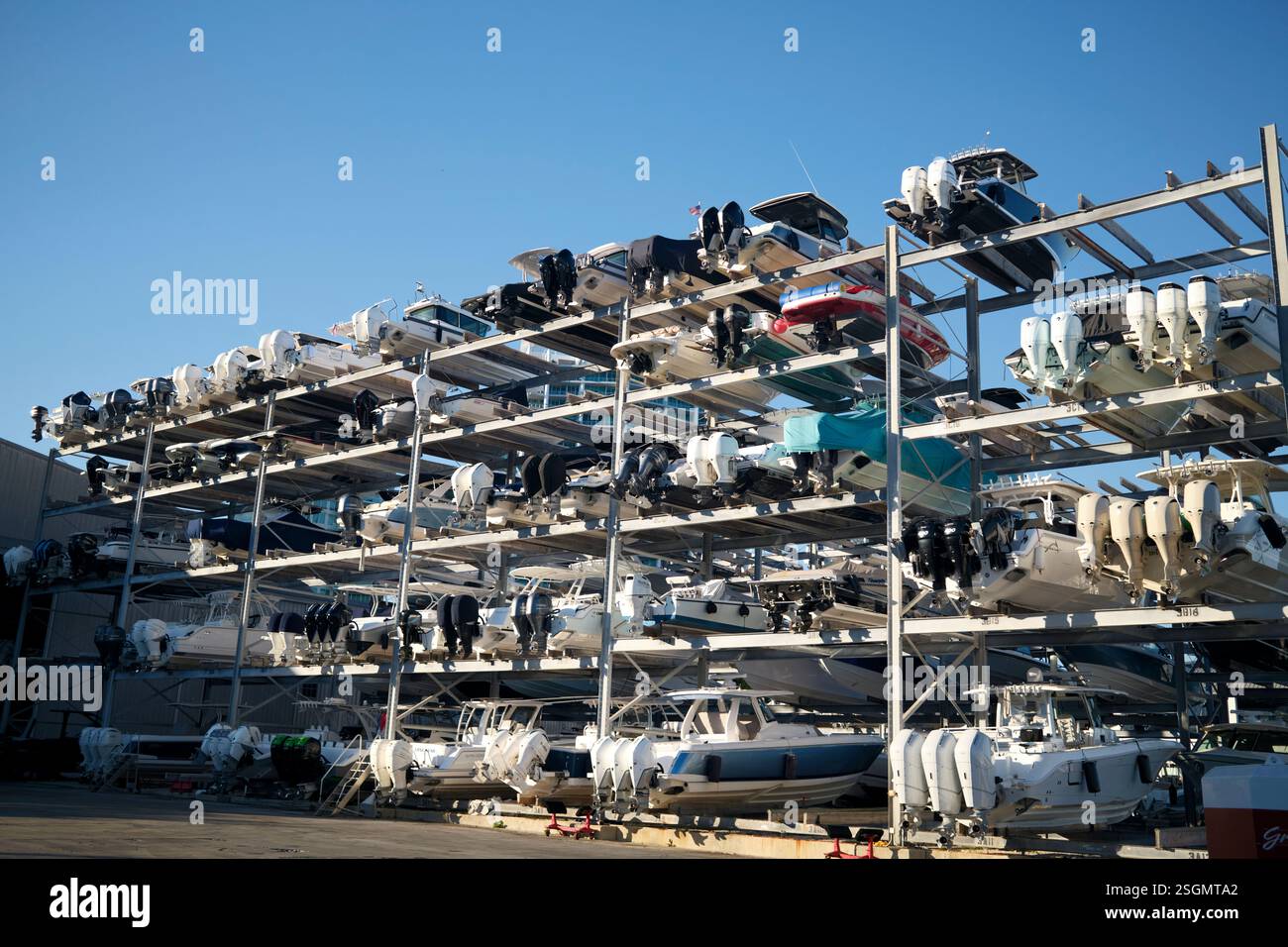 Stacked boat storage filled with various motorboats under a clear blue ...