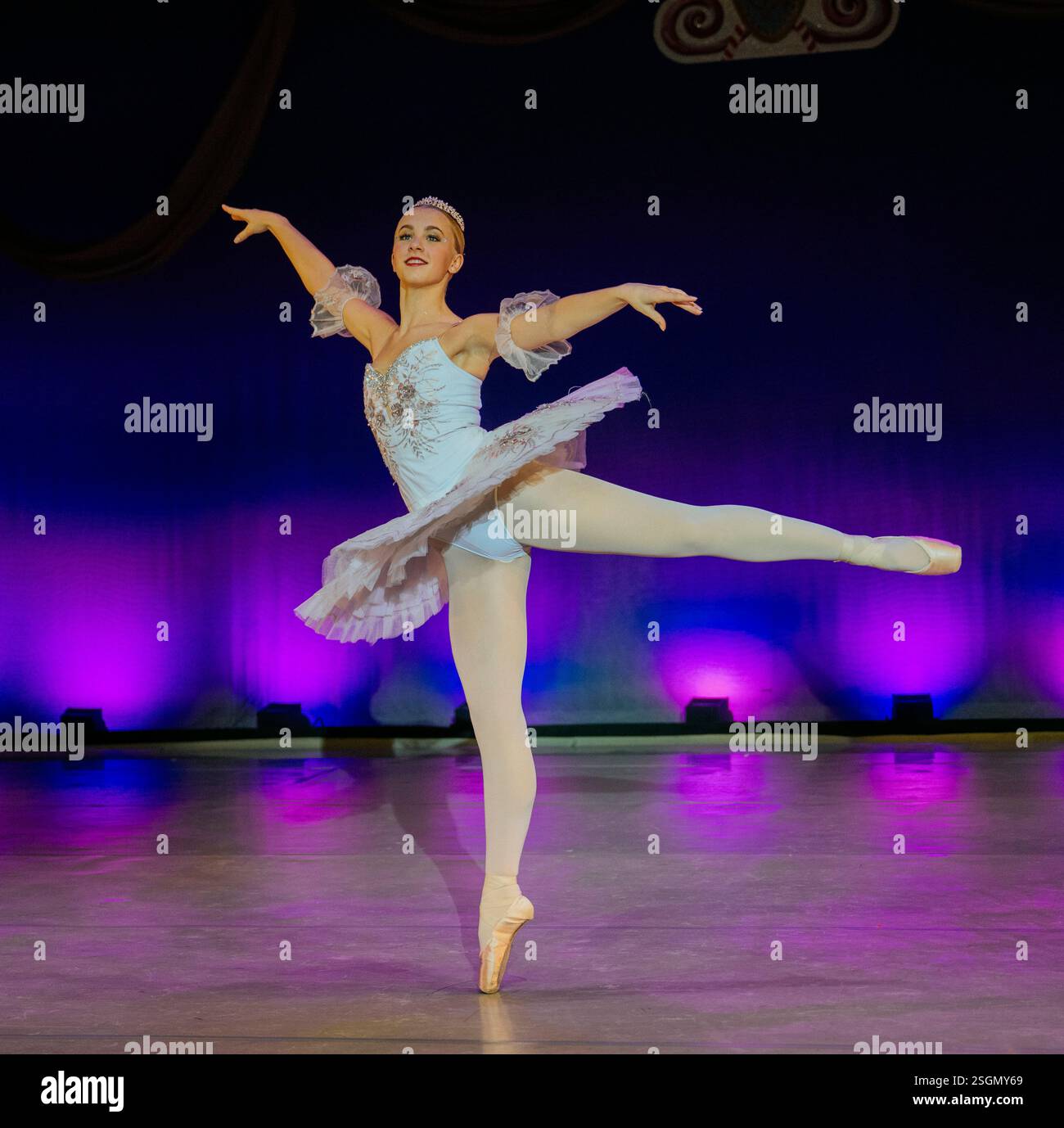 Ballet dancer in a graceful pose on stage with colorful lighting in the ...