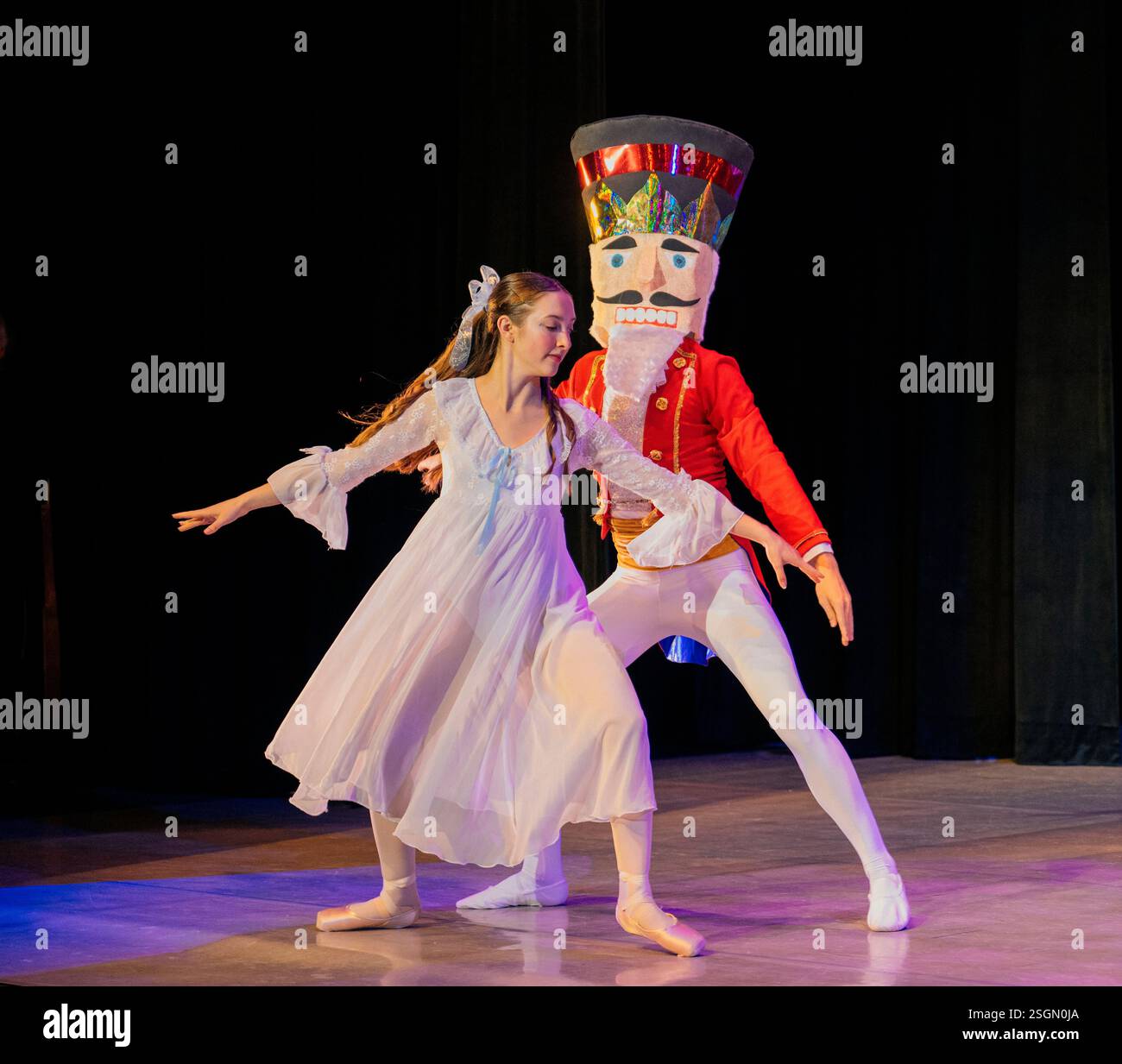 Ballet dancers performing a scene with a Nutcracker character on stage ...