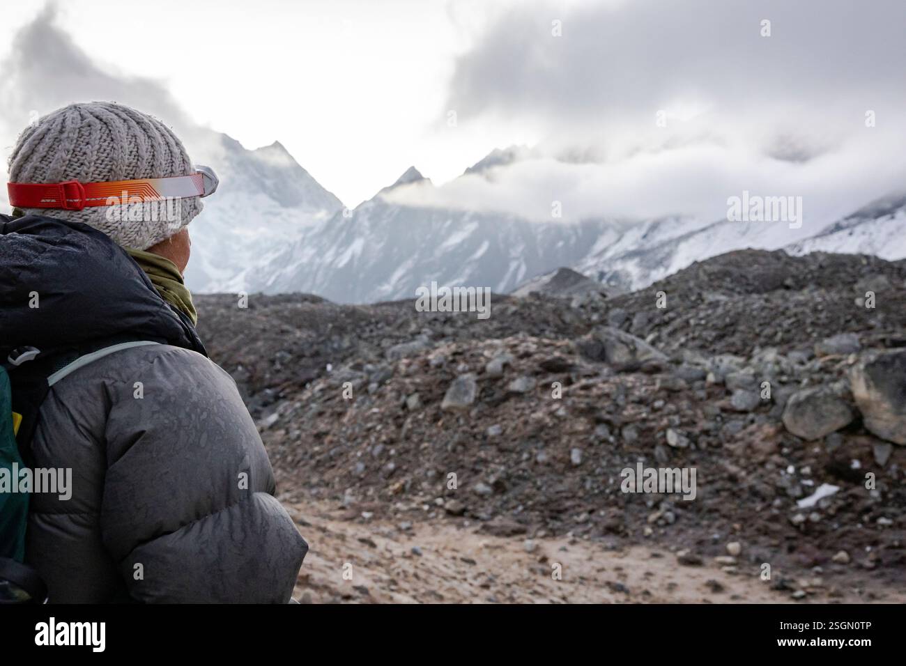 Female wears cold weather gear and headlamp while trekking Nepal Stock ...