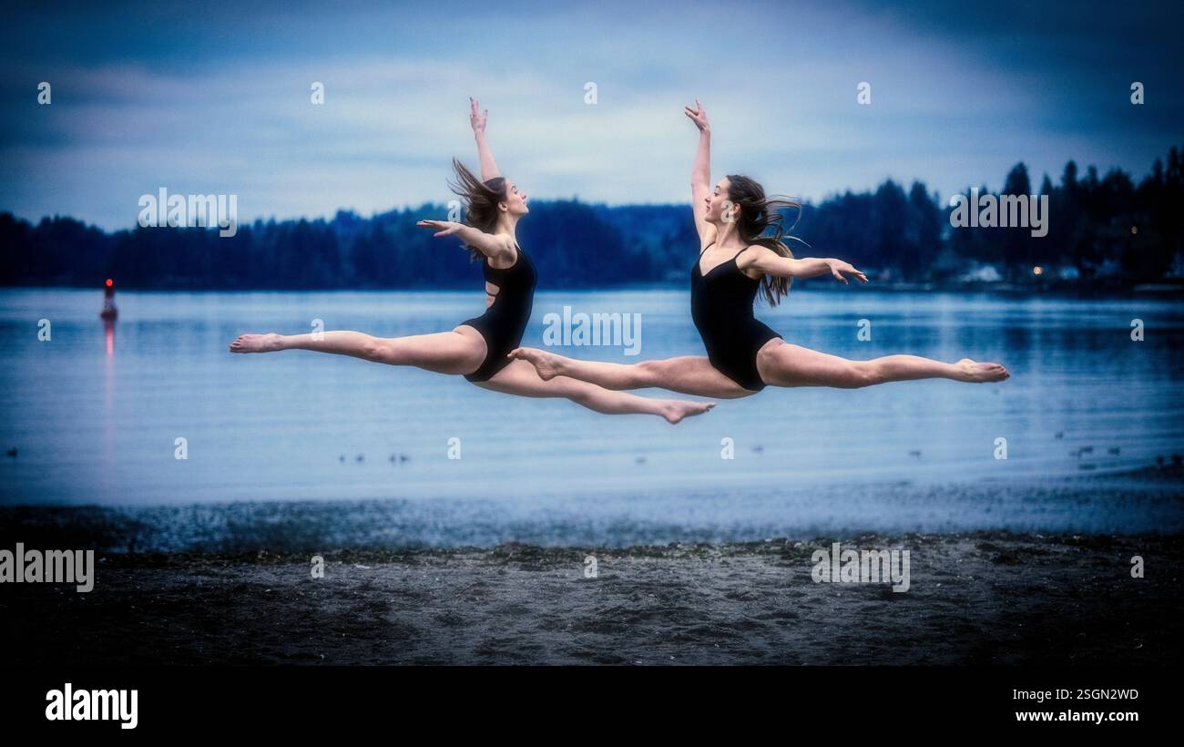 Two ballet dancers gracefully leap in unison by the serene lakeside at ...