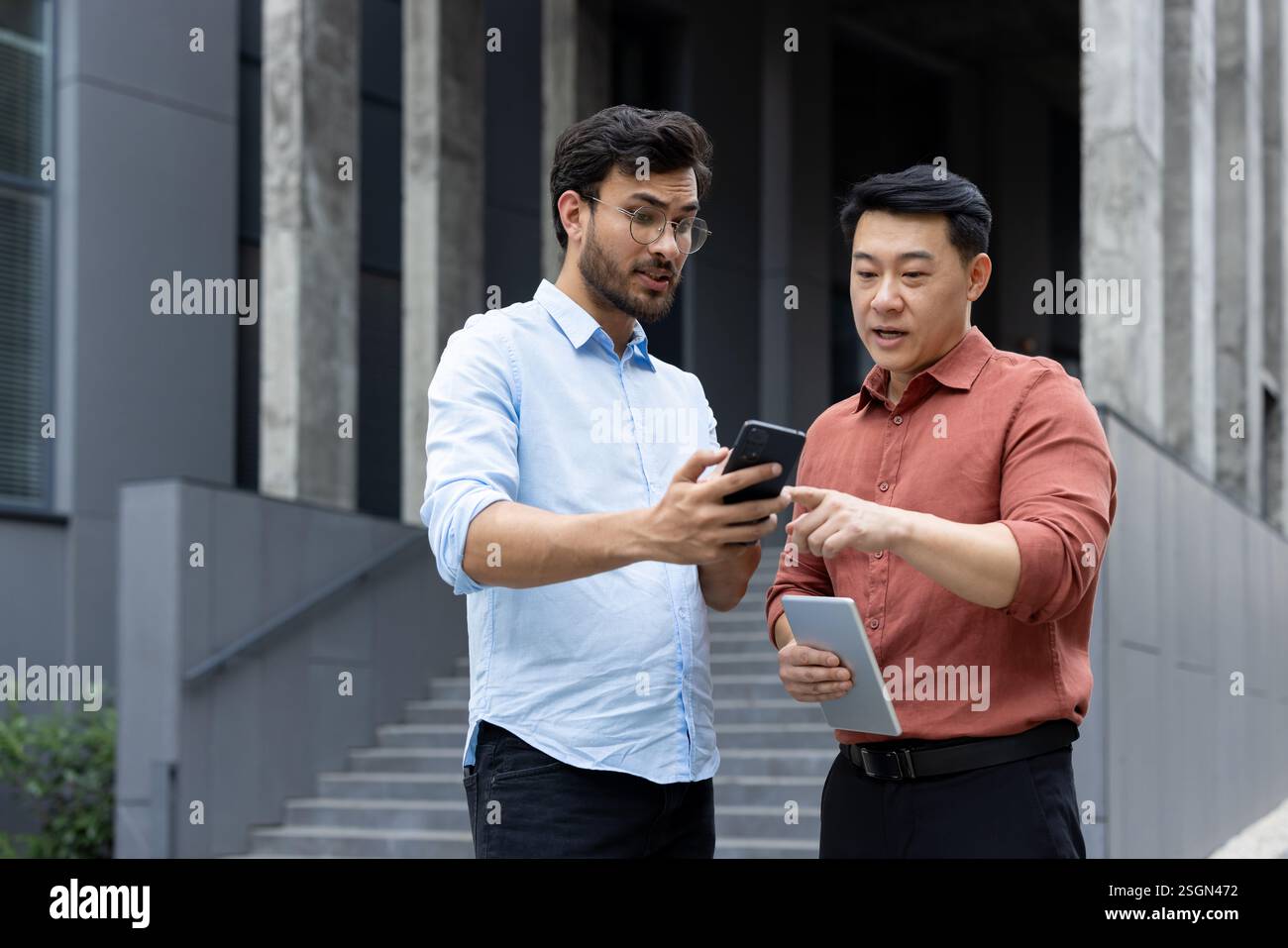 Two serious colleagues are chatting and talking outside the office ...