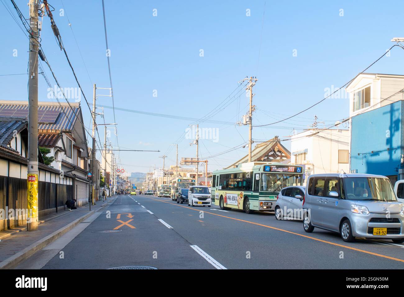 Quiet urban street with cars, buses, and traditional buildings under a ...