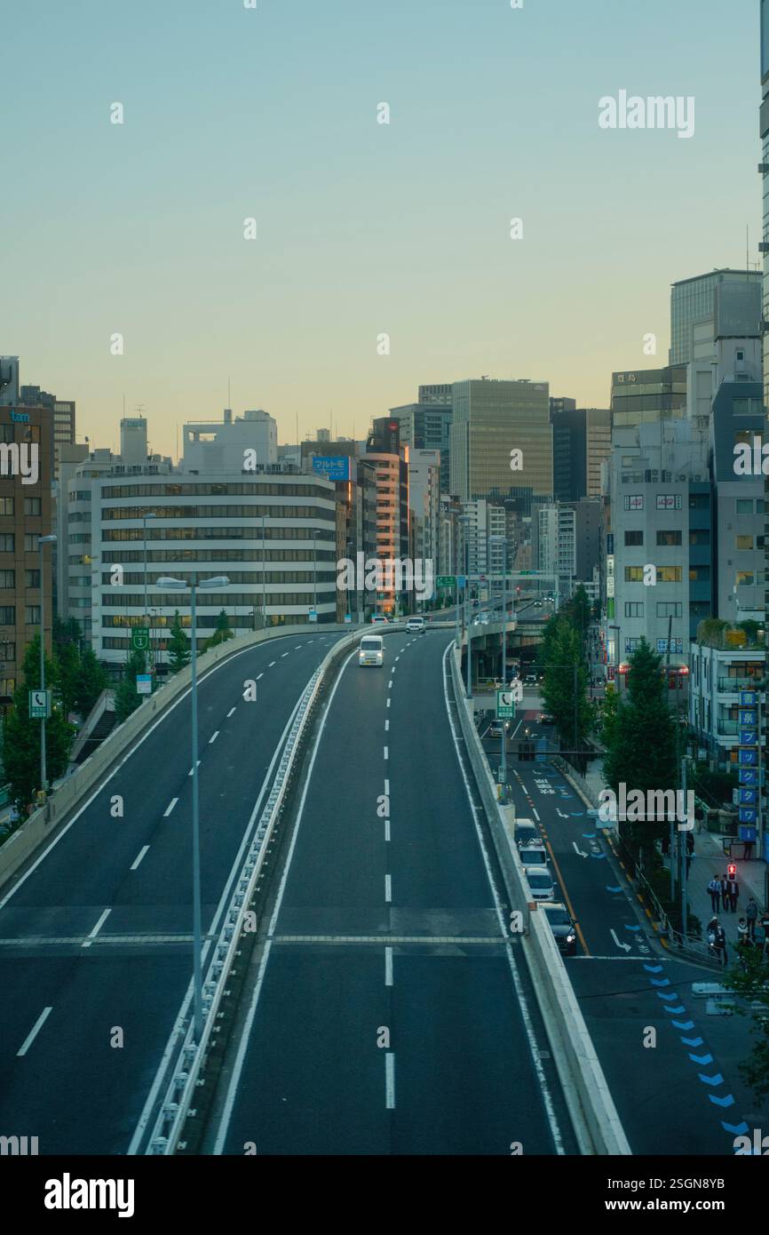 Elevated highway leading into a cityscape with tall buildings at dusk ...