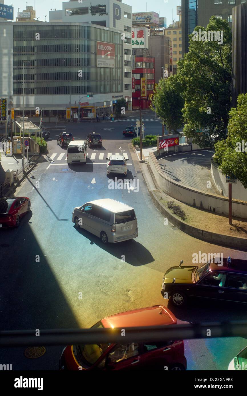 Urban intersection with vehicles and rainbow light effect on the road. Tokyo, Japan Stock Photo ...