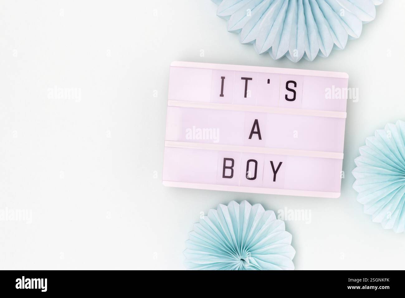 It's a boy. Lightbox with letters and tissue paper fans in a blue color ...