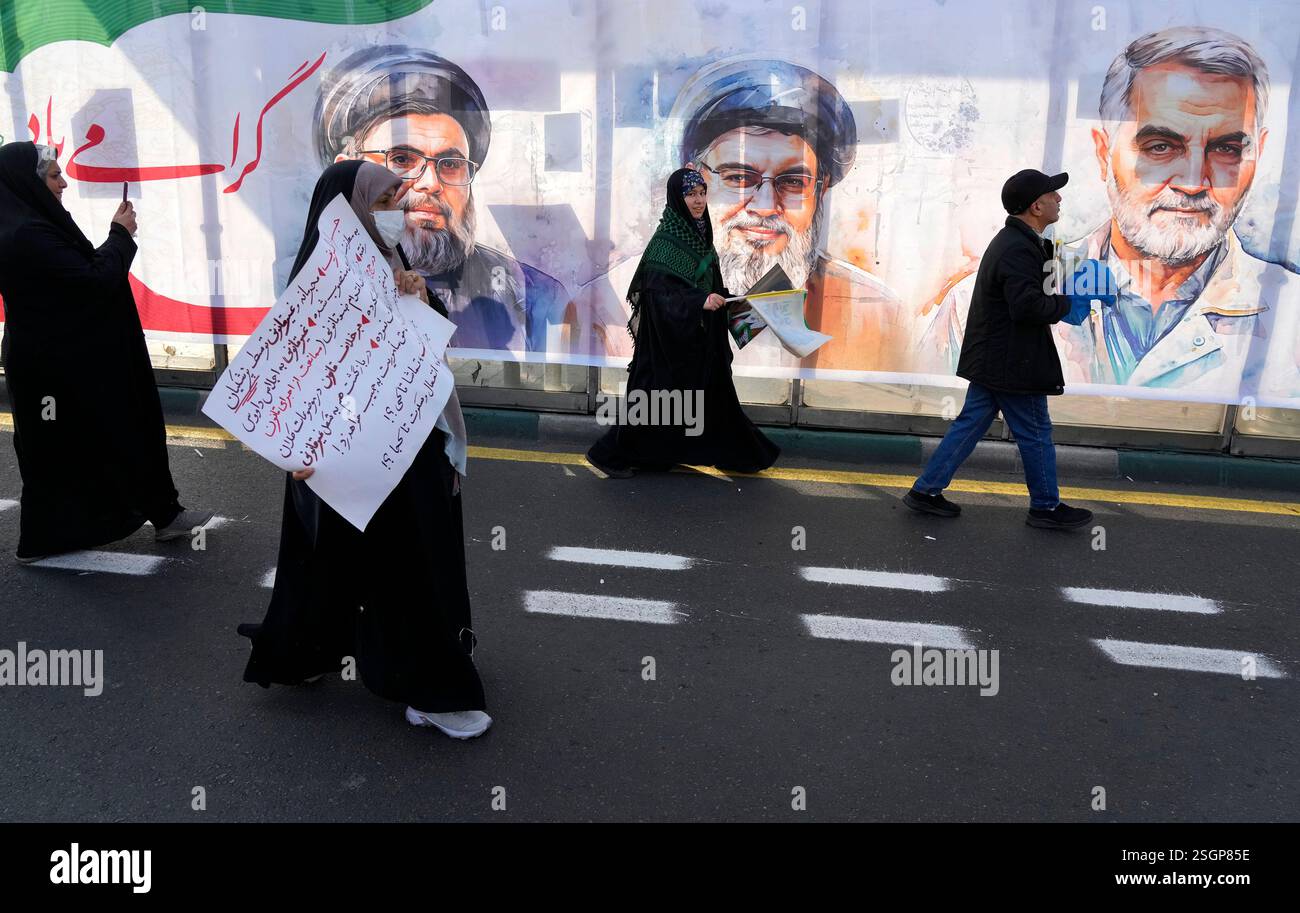 People march in front of portraits of the late commander of Iran's ...