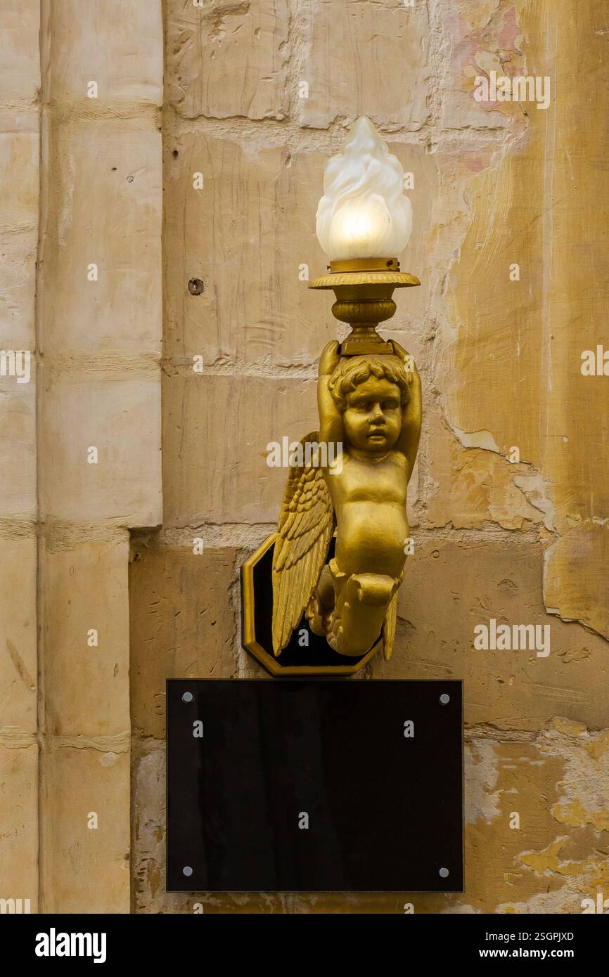 Golden Angel Shaped Lamp Ornament Affixed to Rustic Stone Wall Interior ...