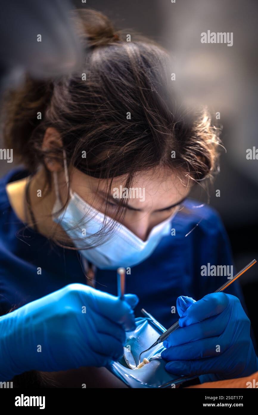 The dentist treats the child's tooth using a rubber dam. Close-up of ...