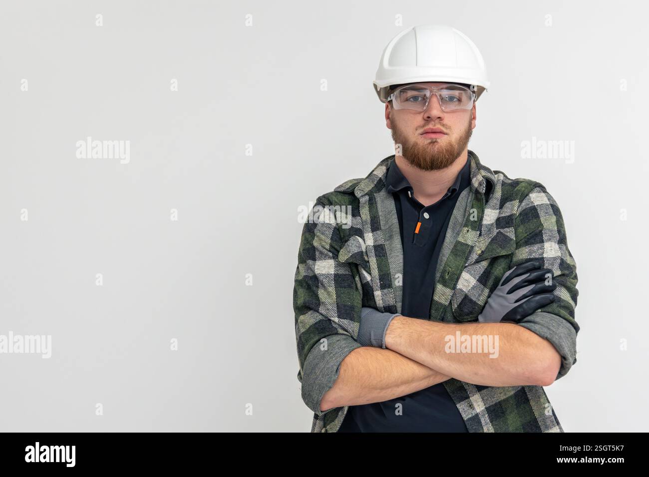 Portrait of a male builder. Engineer in overalls and helmet on a light ...