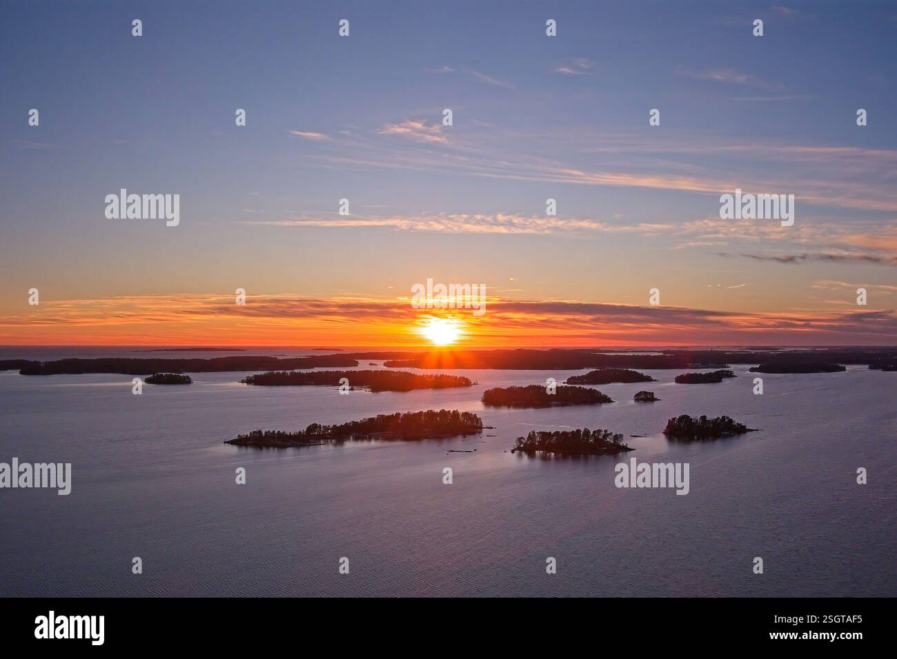 Aerial view of sunset over the sea and islands in winter with clouds in ...
