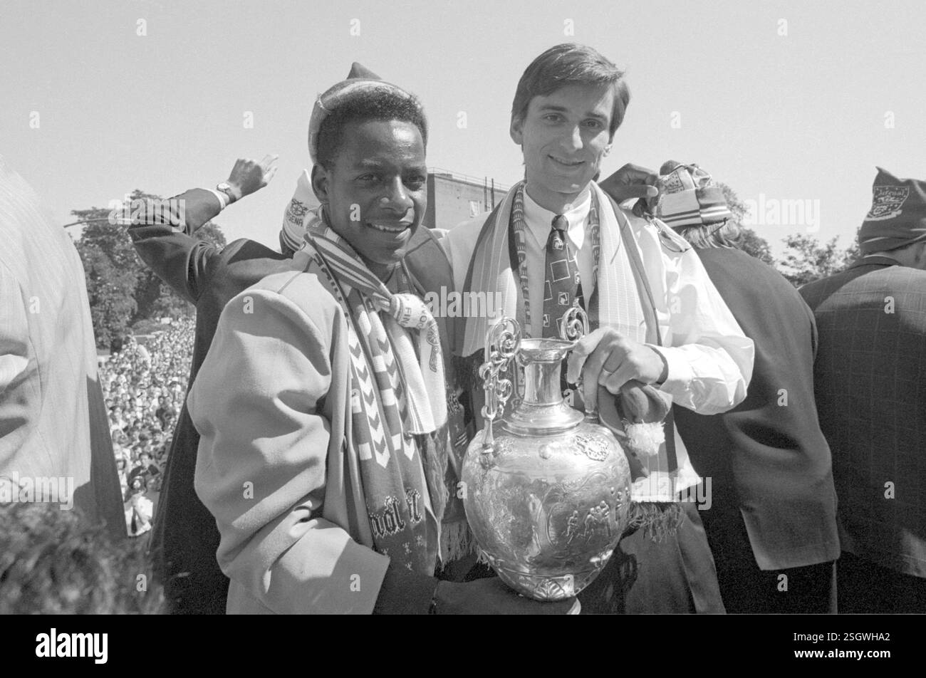 Michael Thomas and Alan Smith with the League trophy on the open top ...