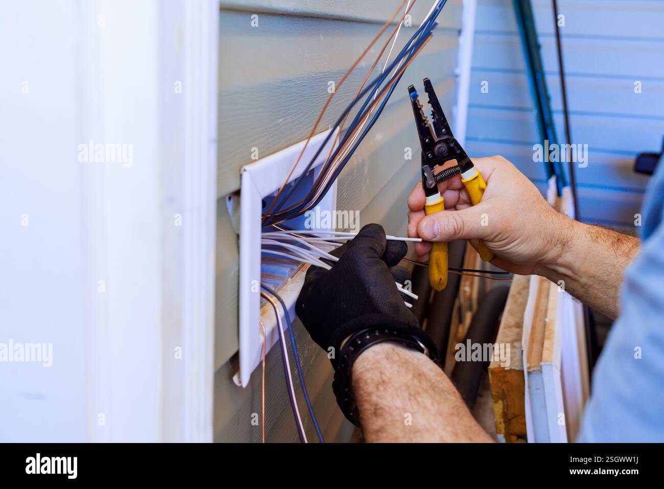 Contractor electrician uses tools to connect wires while during ...