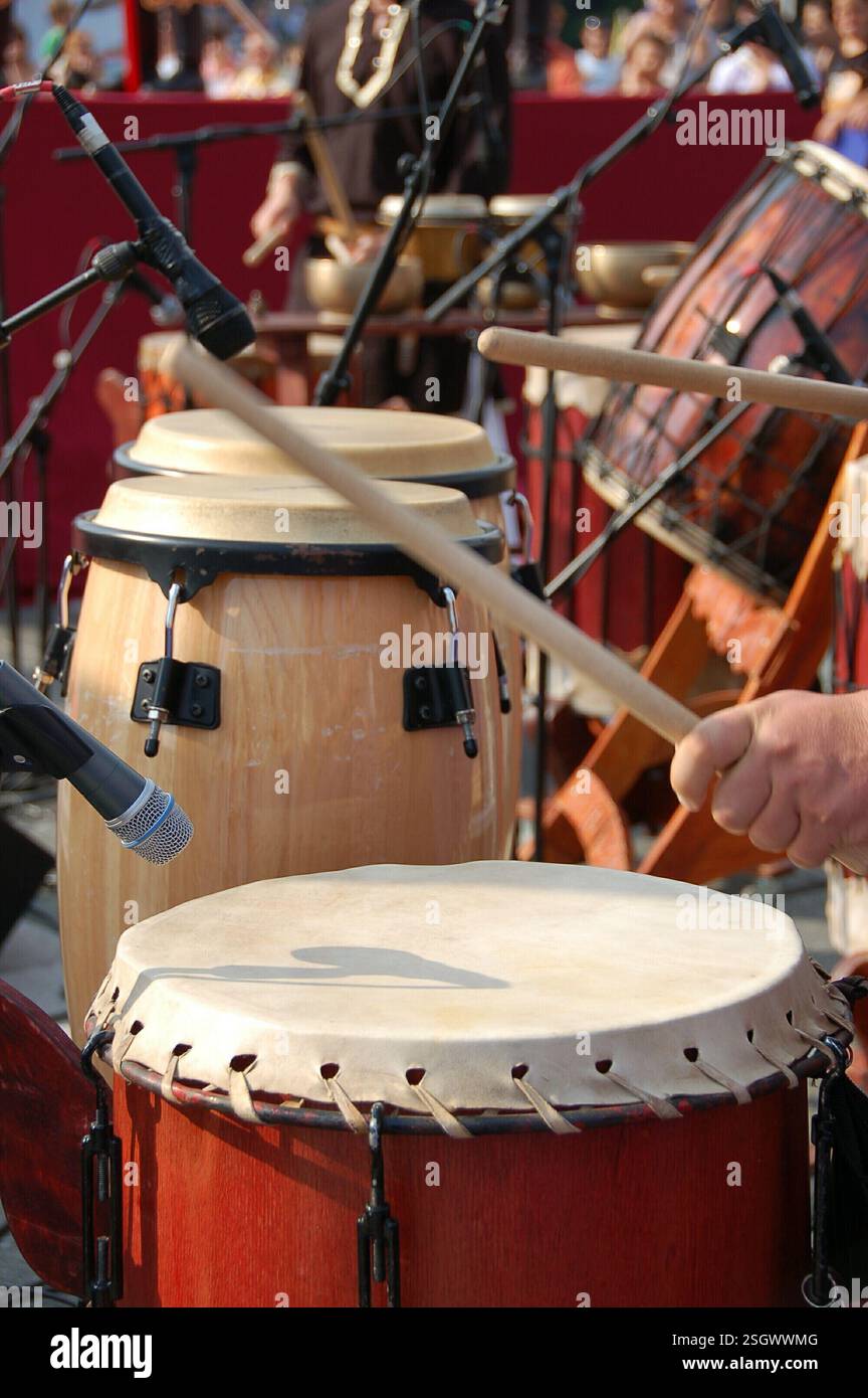 Traditional drums and drumsticks in action on an outdoor event stage ...
