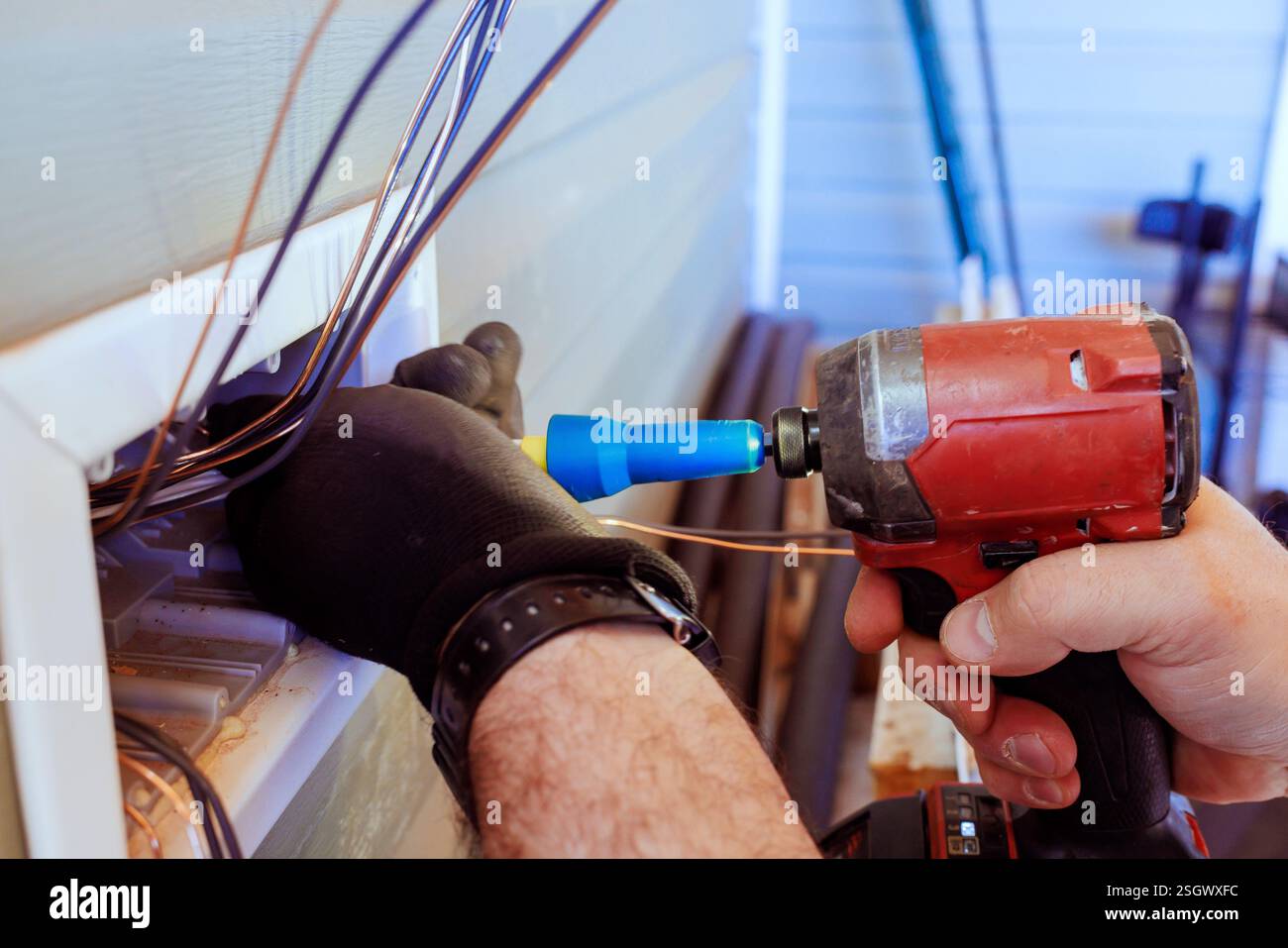 Technician worker is connecting electrical wires with screwdriver power ...