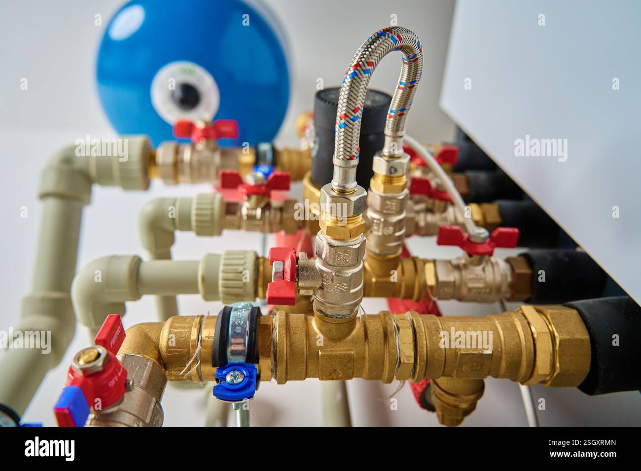 Close-up of heating system featuring plastic pipes, brass fittings, and ...