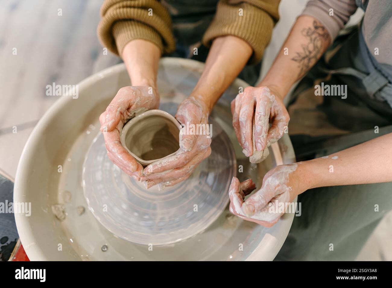 Mentor teaches pottery fundamentals, demonstrating sculpting skills on ...