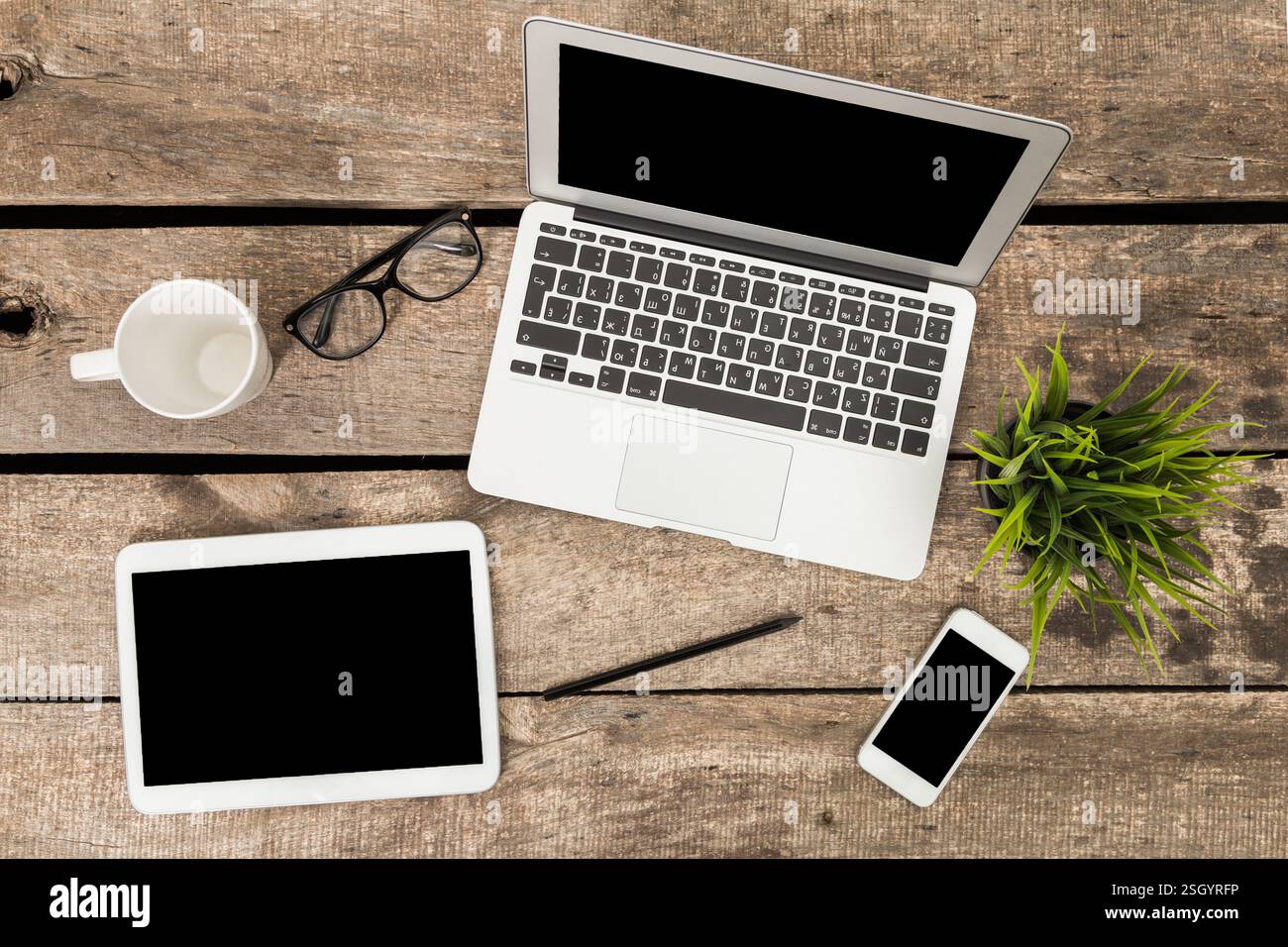 Workstation setup with laptop, tablet, smartphone, and accessories on ...