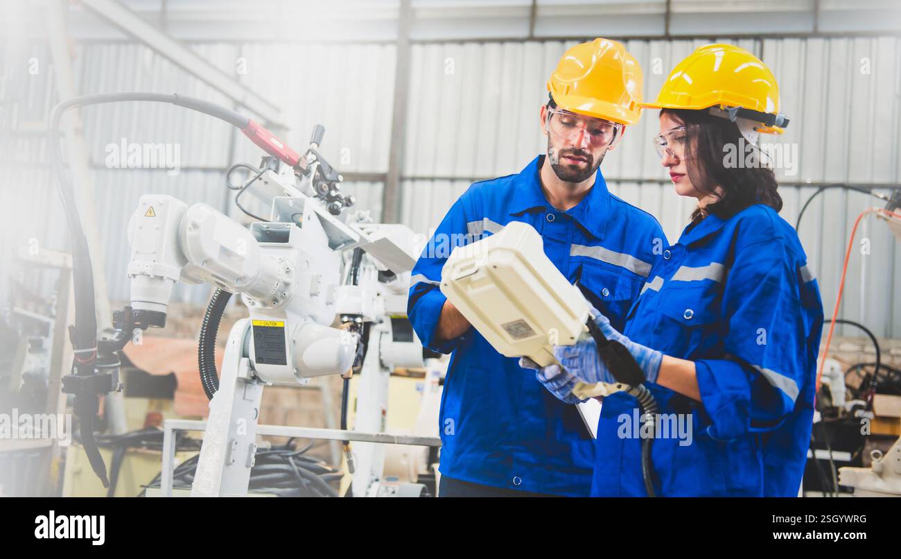Engineers mechanic using computer controller Robotic arm for welding steel in steel factory ...