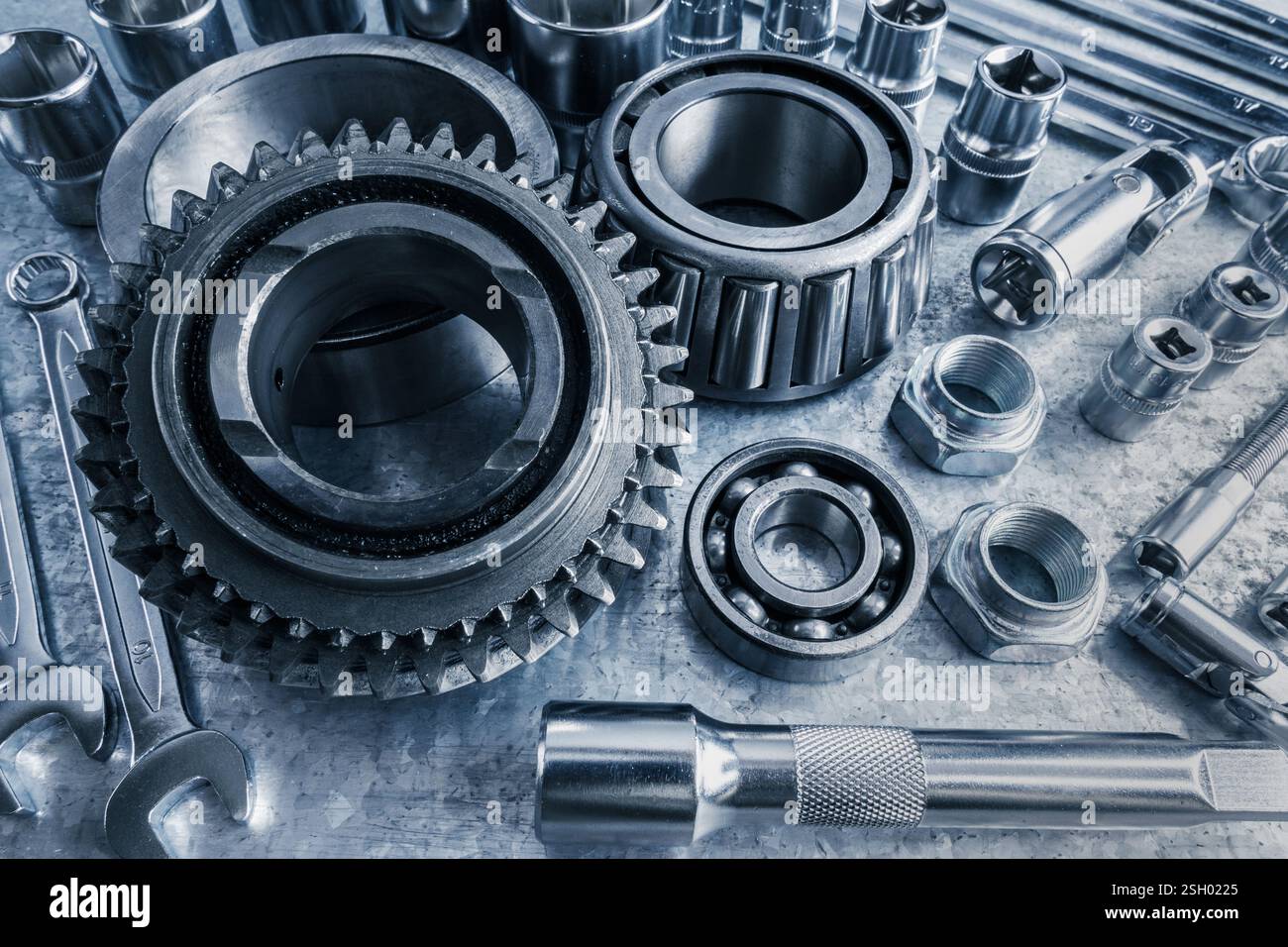Collection of various metal tools and parts arranged on a workbench in ...