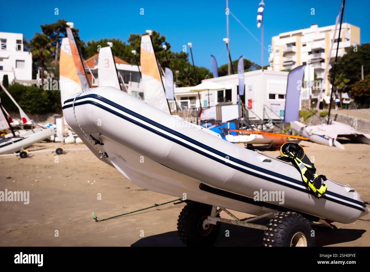 Rubber boat kayak with wheels and ships on beautiful sea beach in sunny ...