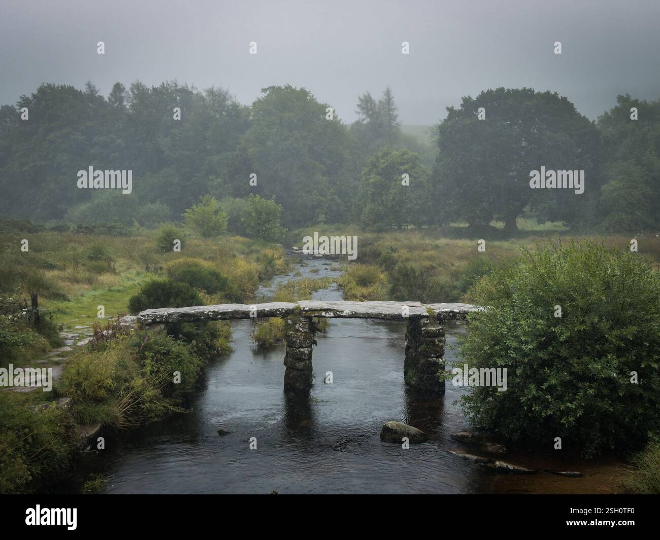 Postbridge Clapper Bridge over the East Dart River on a foggy and rainy ...