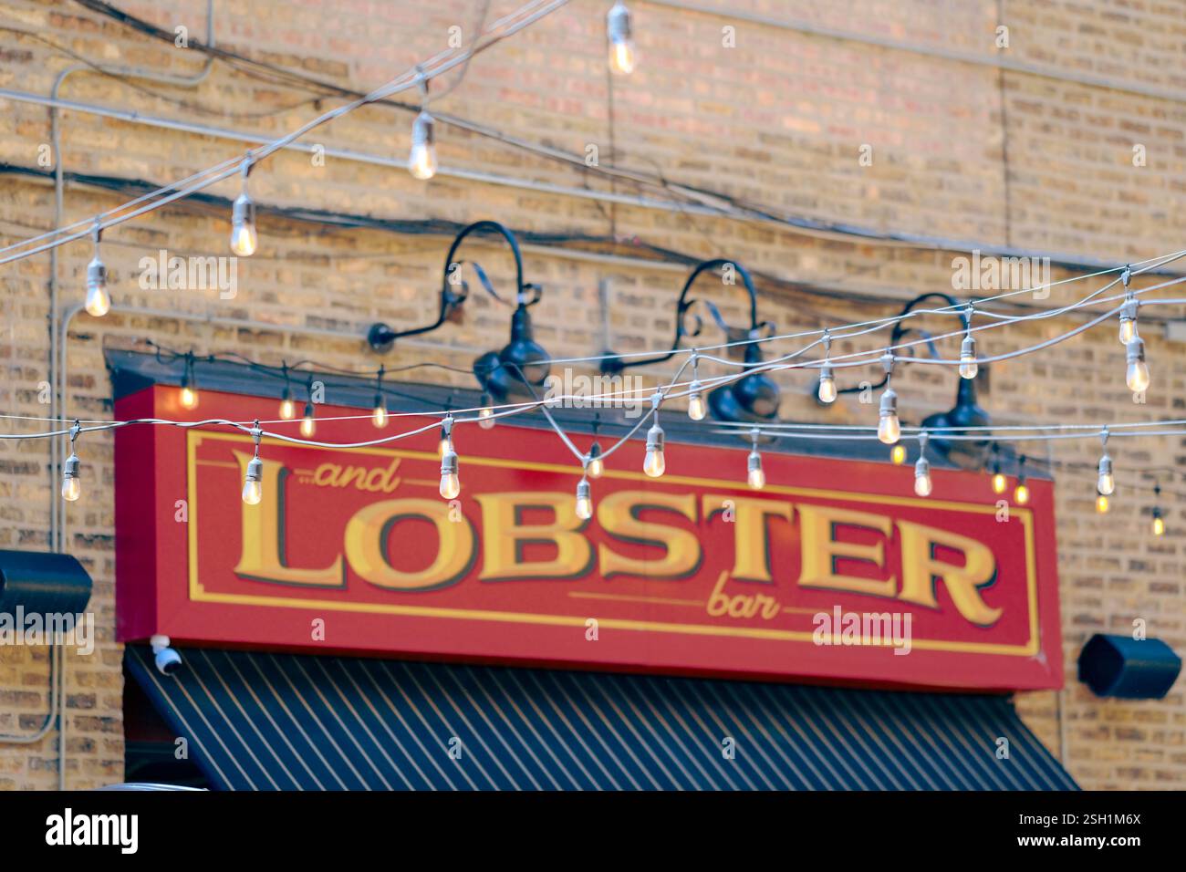 And Lobster Bar Sign on Brick Wall with Hanging Lights Stock Photo - Alamy