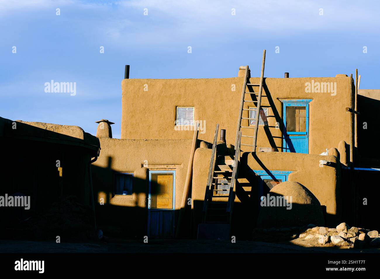 Adobe Architecture with Blue Door and Ladders Stock Photo - Alamy