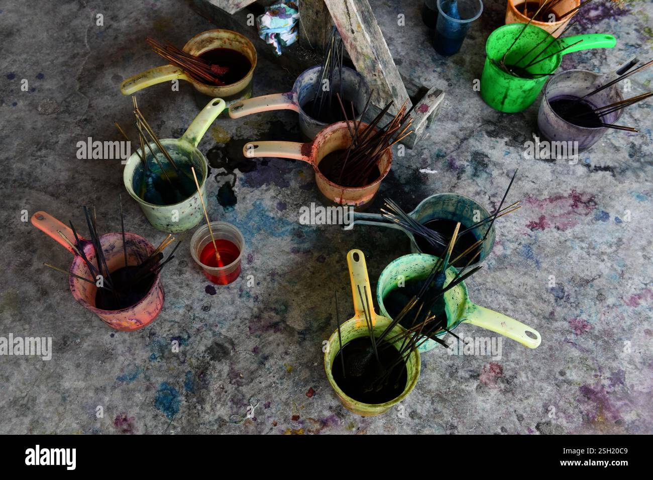 Plastic containers on a studio floor hold brushes and a variety of dye ...
