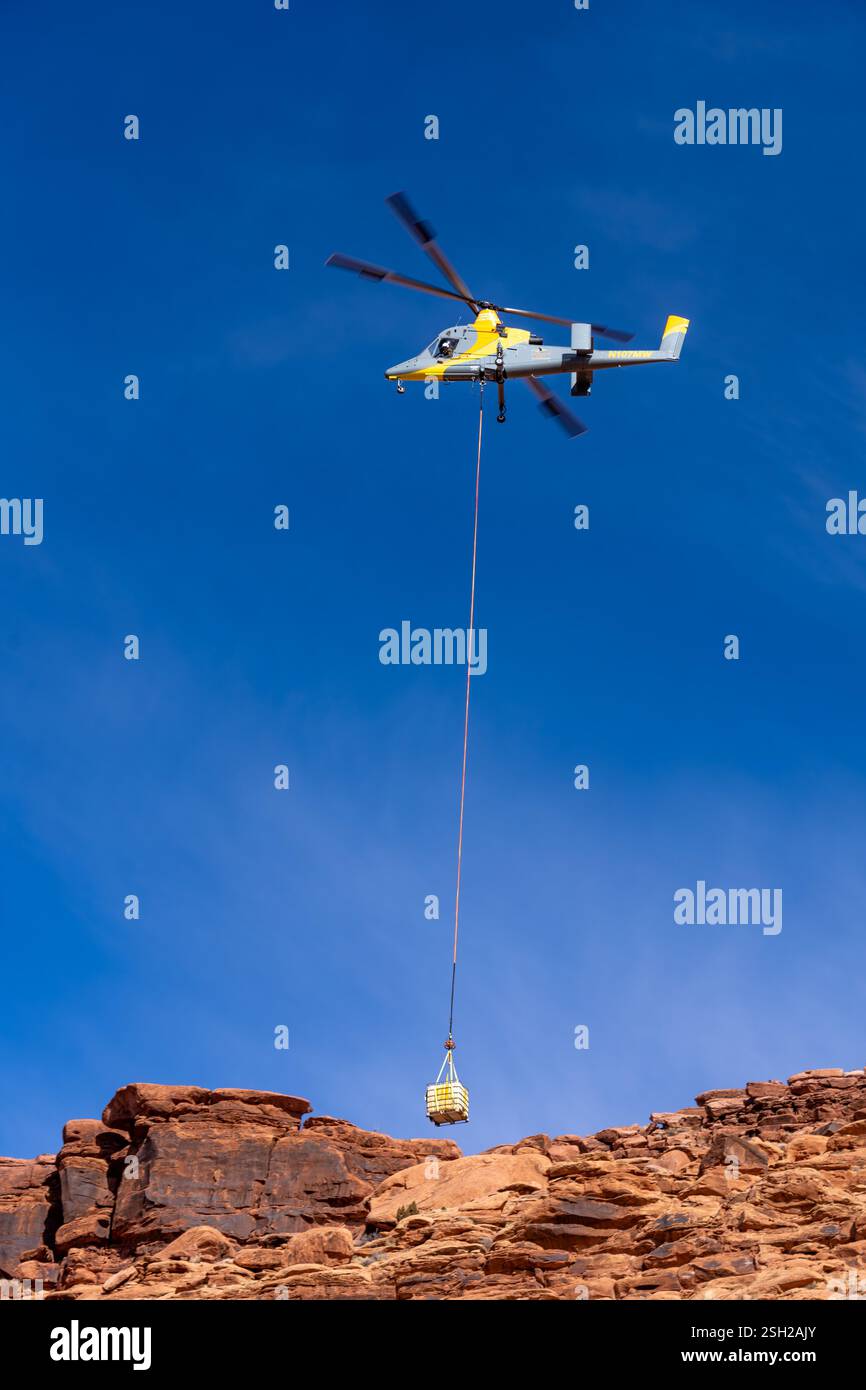 A Kaman K-1200 K-MAX heavy lift helicopter removing debris on a ...