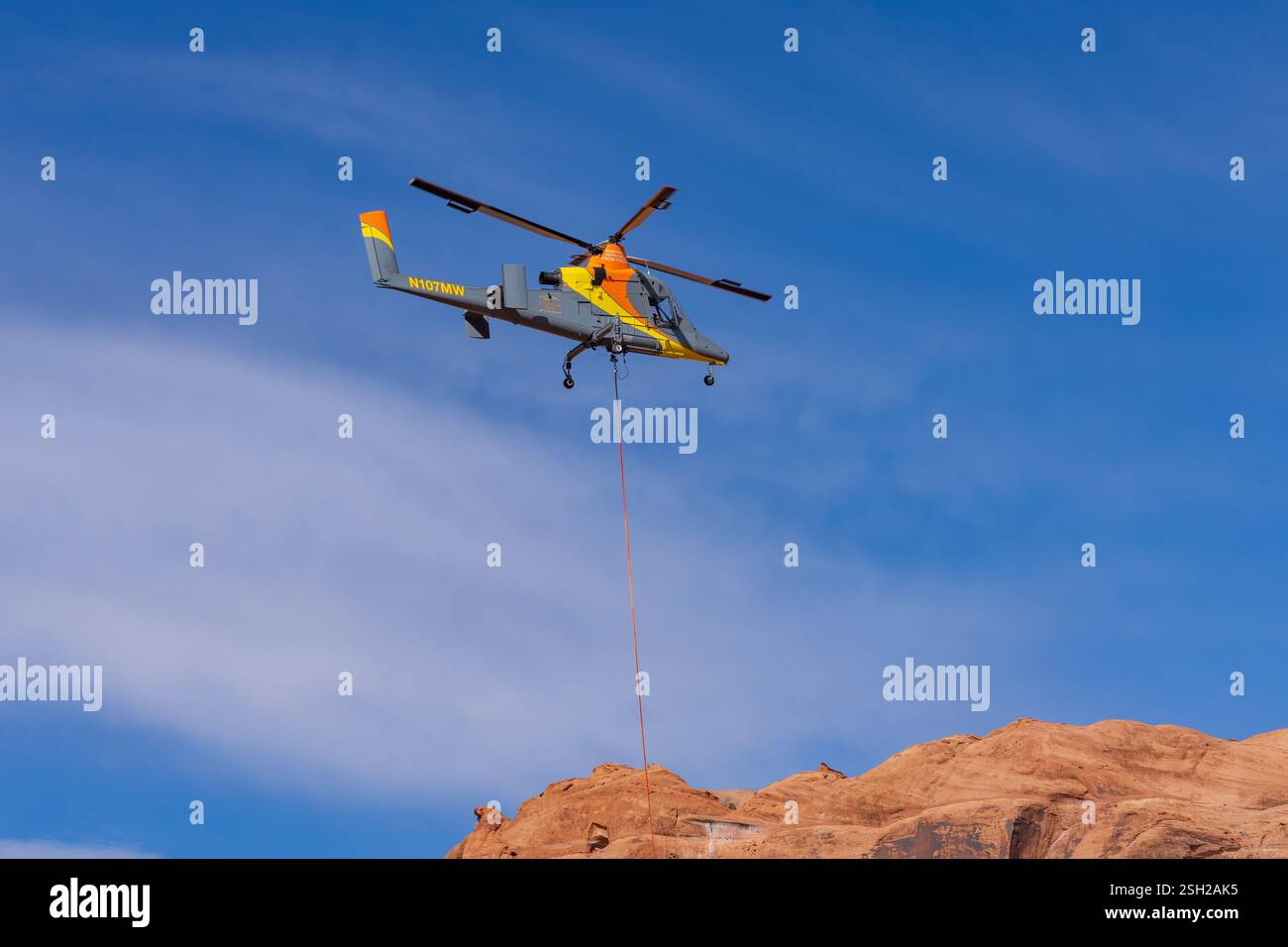 A Kaman K-1200 K-MAX heavy lift helicopter removing debris on a ...