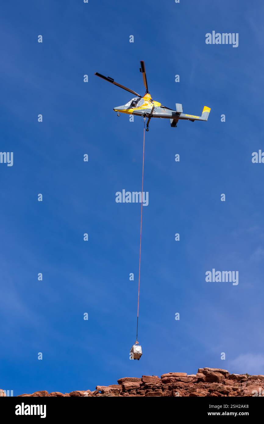 A Kaman K-1200 K-MAX heavy lift helicopter removing debris on a ...