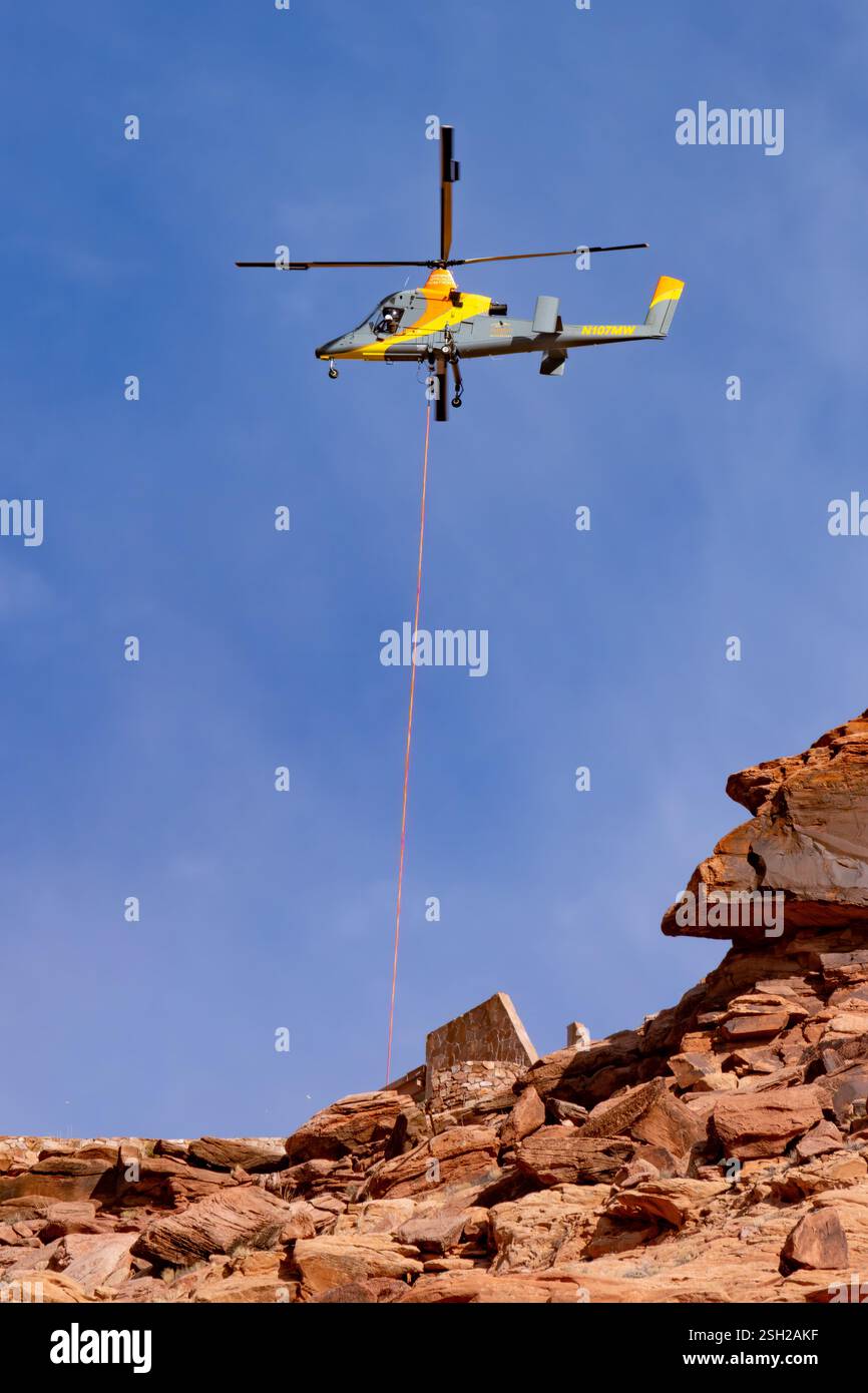 A Kaman K-1200 K-MAX heavy lift helicopter removing debris on a ...