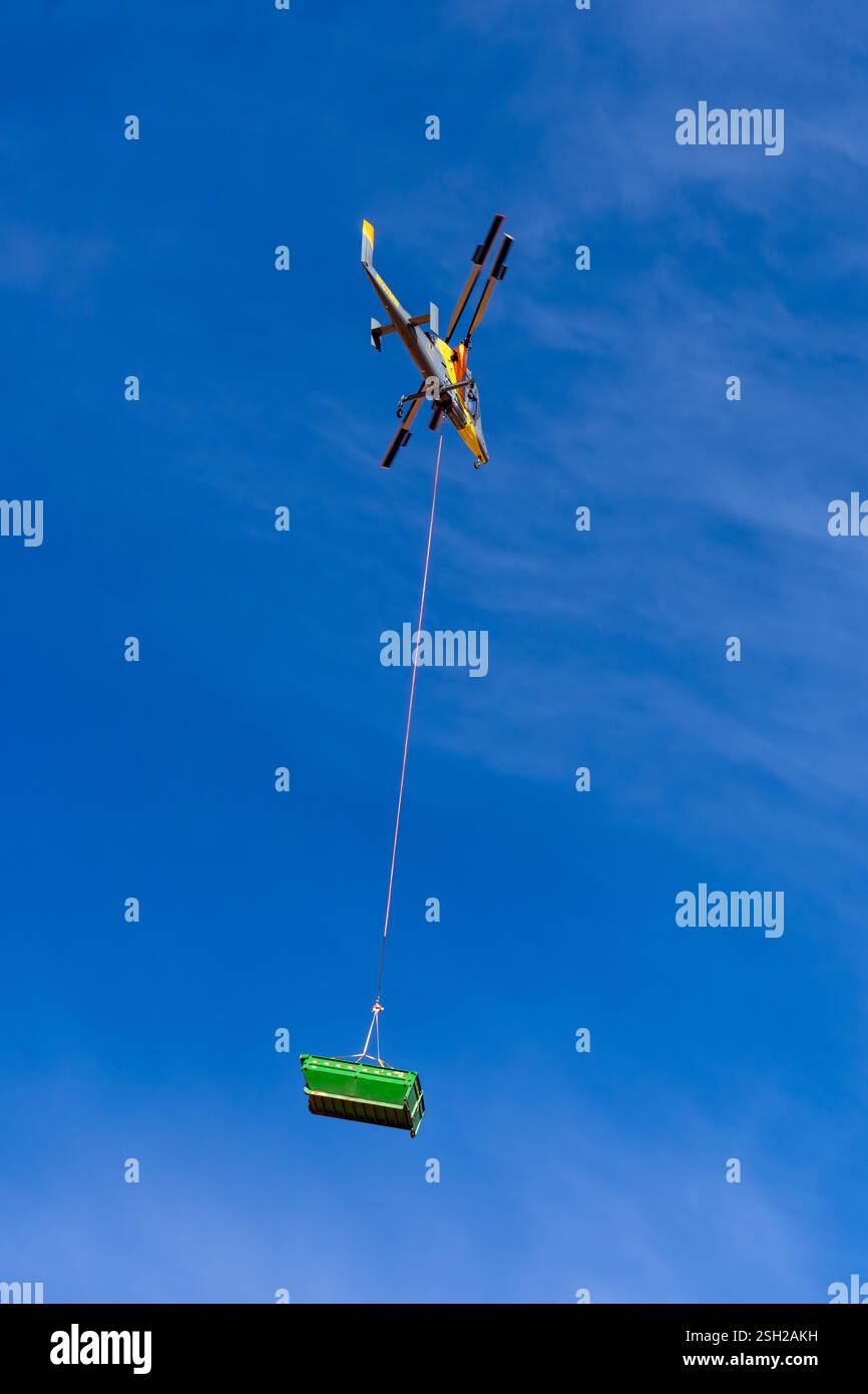 A Kaman K-1200 K-MAX heavy lift helicopter removing debris on a ...