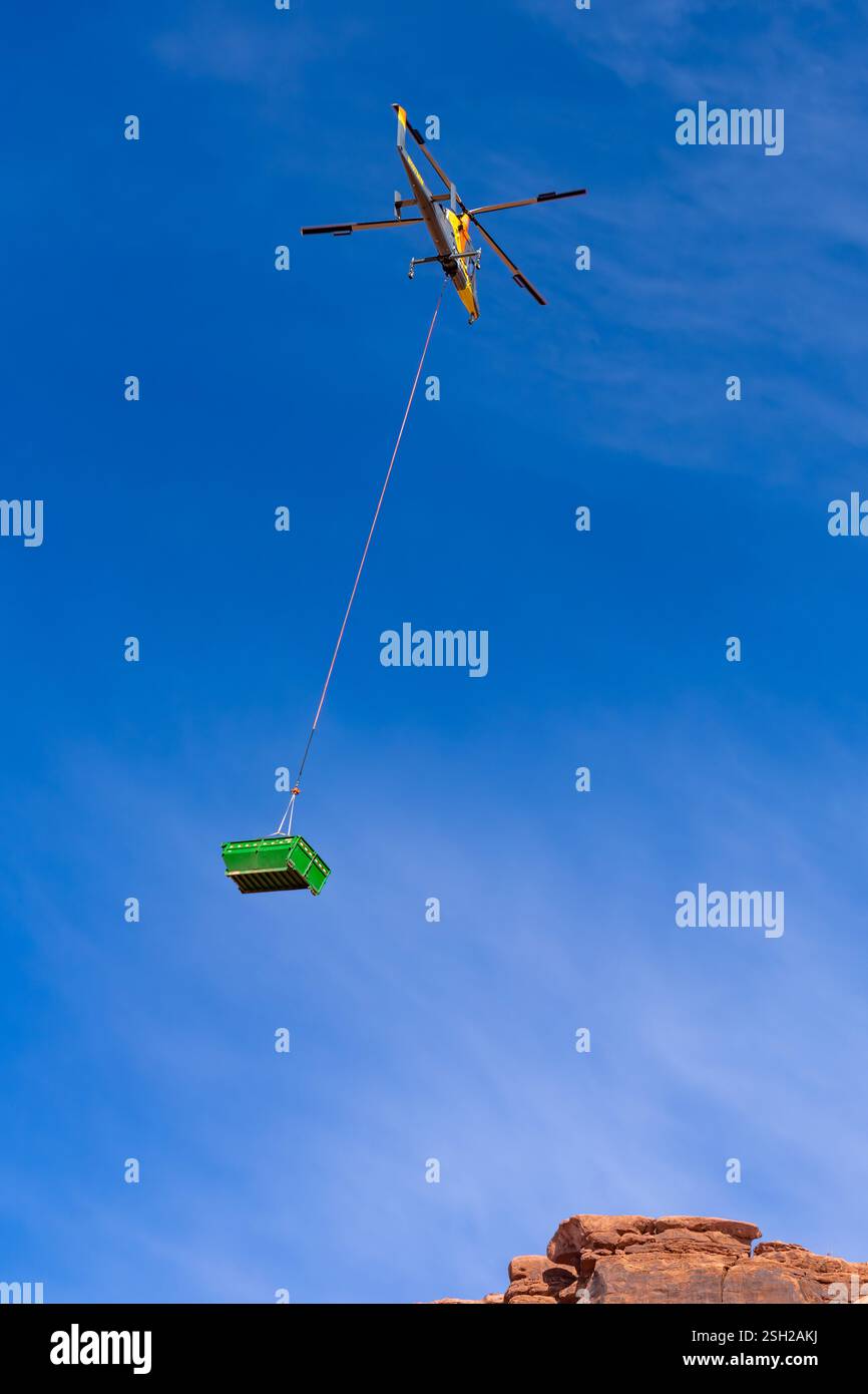 A Kaman K-1200 K-MAX heavy lift helicopter removing debris on a ...