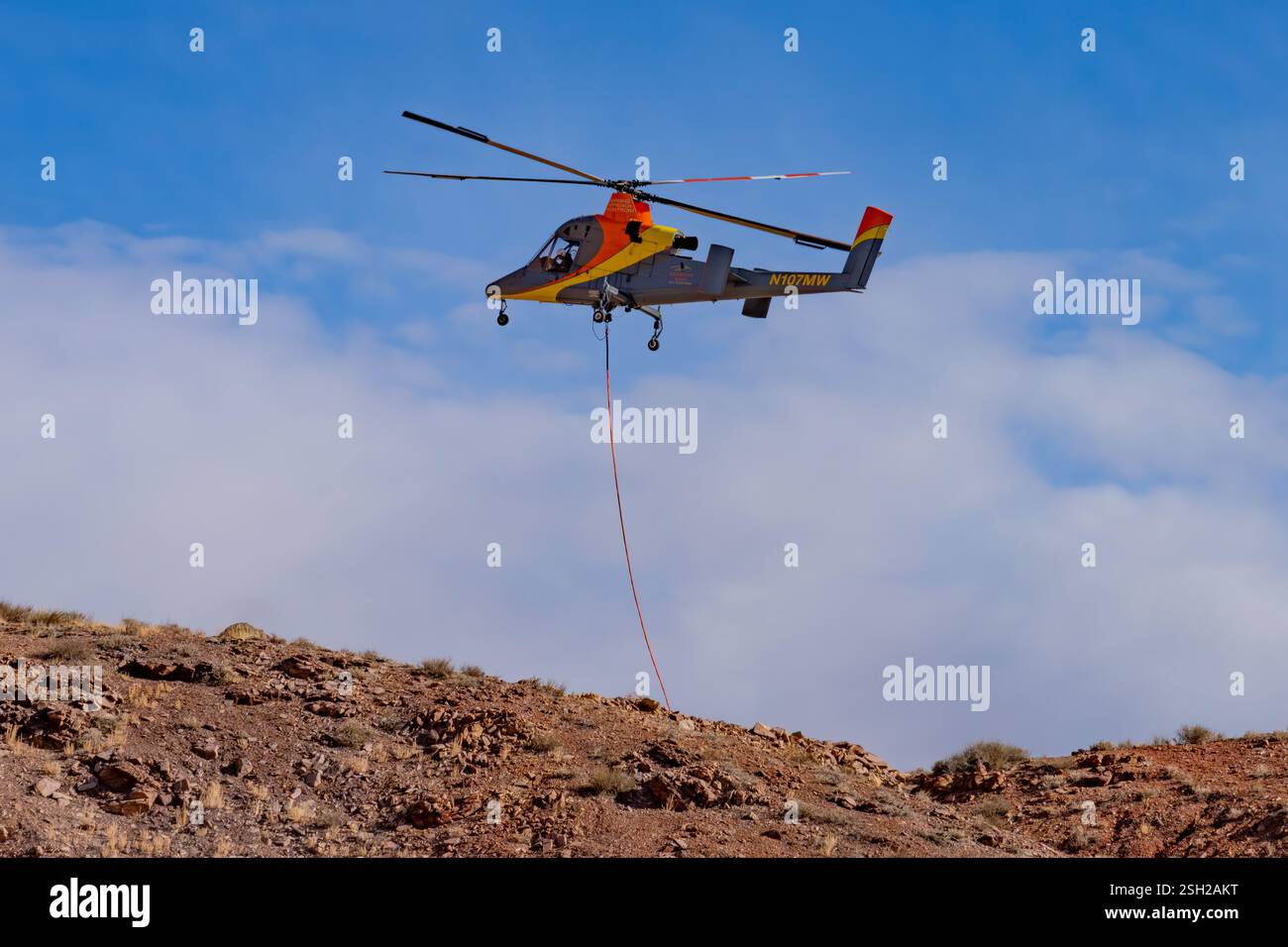 A Kaman K-1200 K-MAX heavy lift helicopter removing debris on a ...