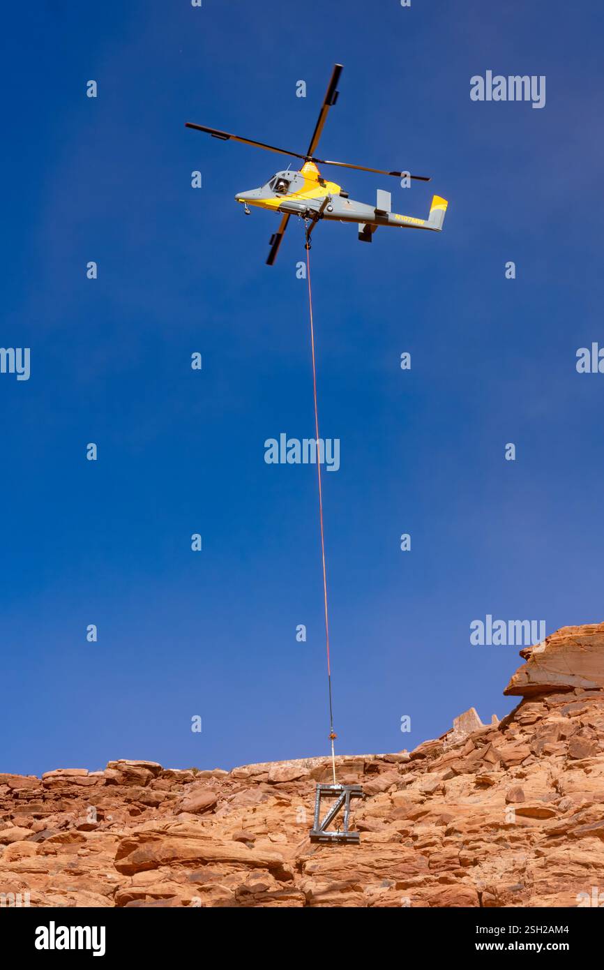 A Kaman K-1200 K-MAX heavy lift helicopter removing debris on a ...