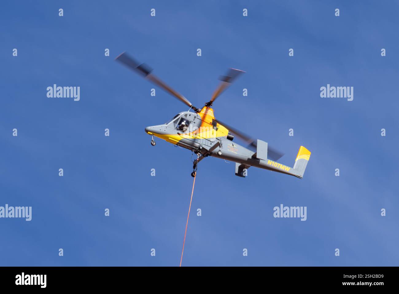 A Kaman K-1200 K-MAX heavy lift helicopter removing debris on a ...