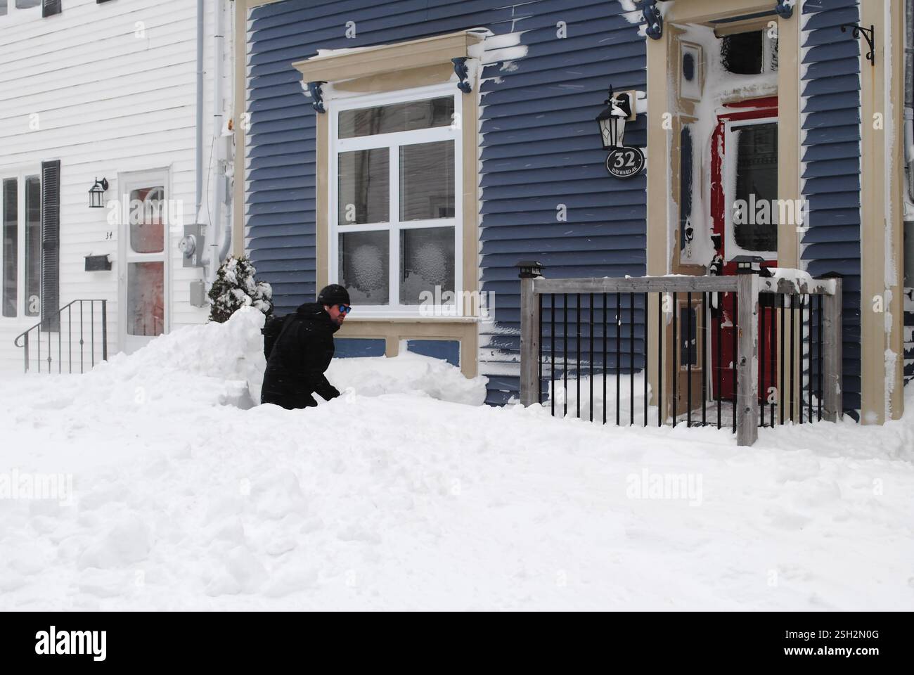 A resident of St. John's, N.L., is shown digging out from under about ...
