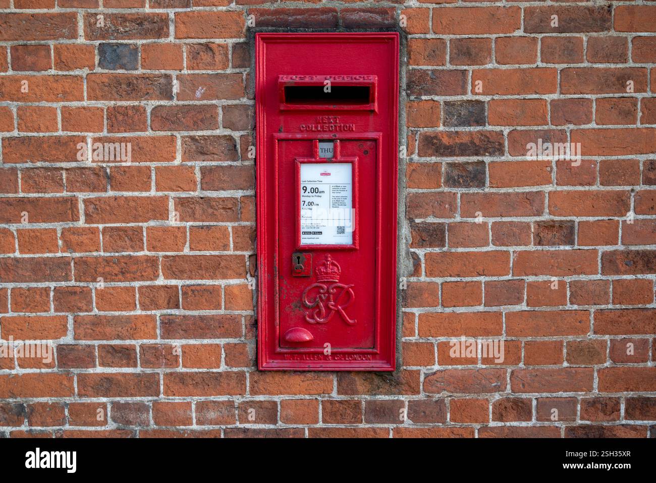 Traditional British post box in a brick wall. This one is marked GR ...