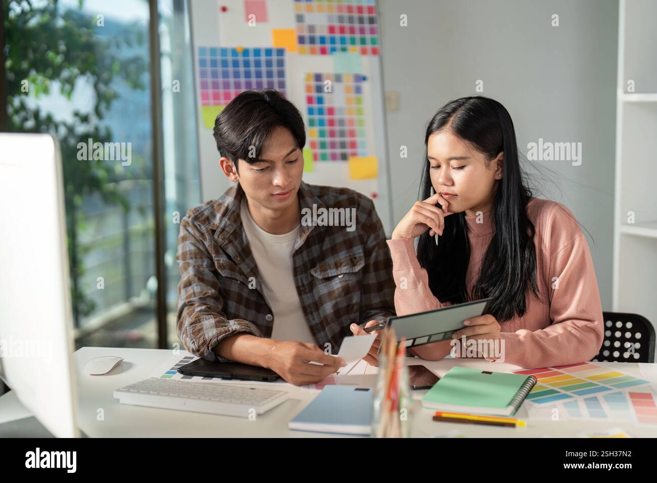 Diverse graphic design team analyzing project details and color schemes ...