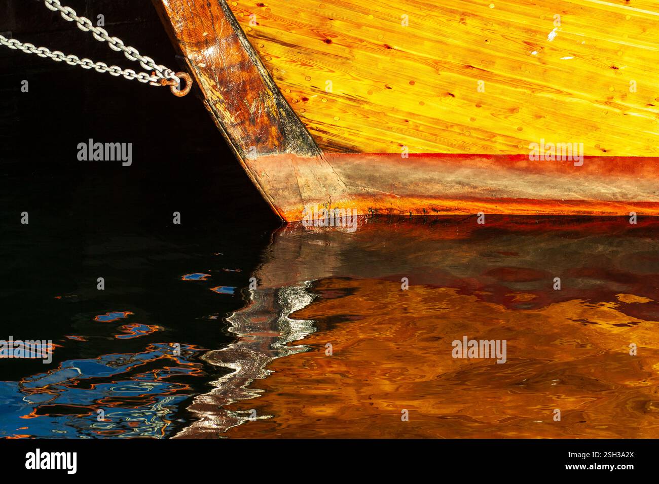 A bright wooden ship keel stands out as its reflection dances on the ...