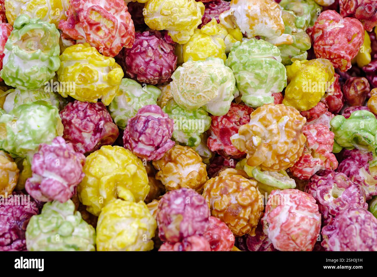 Lots of colorful caramelized sweet popcorn, close up shot, abstract ...