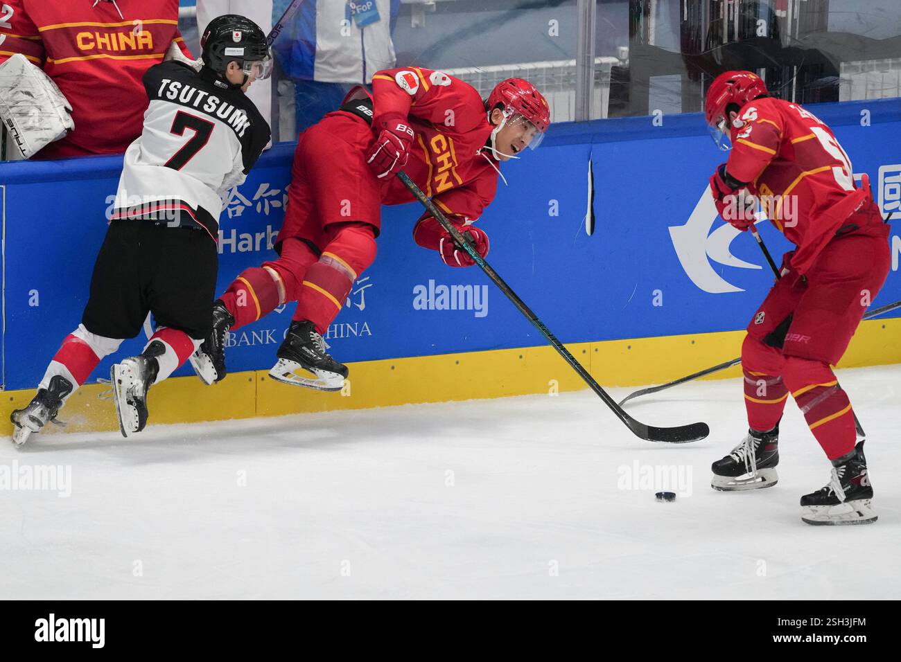 China's Yan Juncheng, center, tries to control the puck against Katoro ...