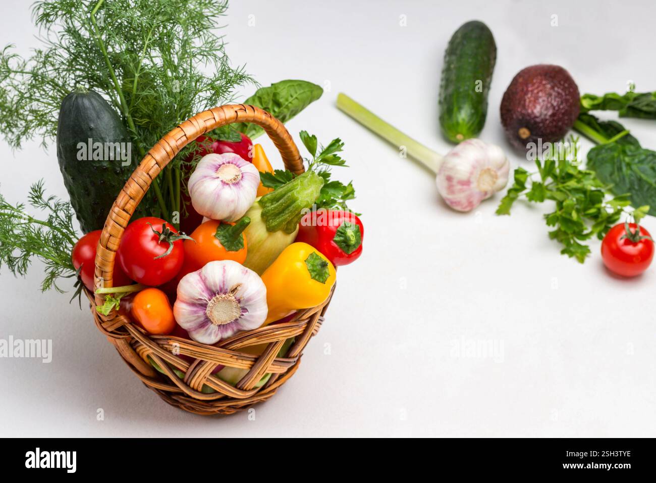 Multi-colored vegetables in wicker basket. Pepper, cucumber, garlic ...